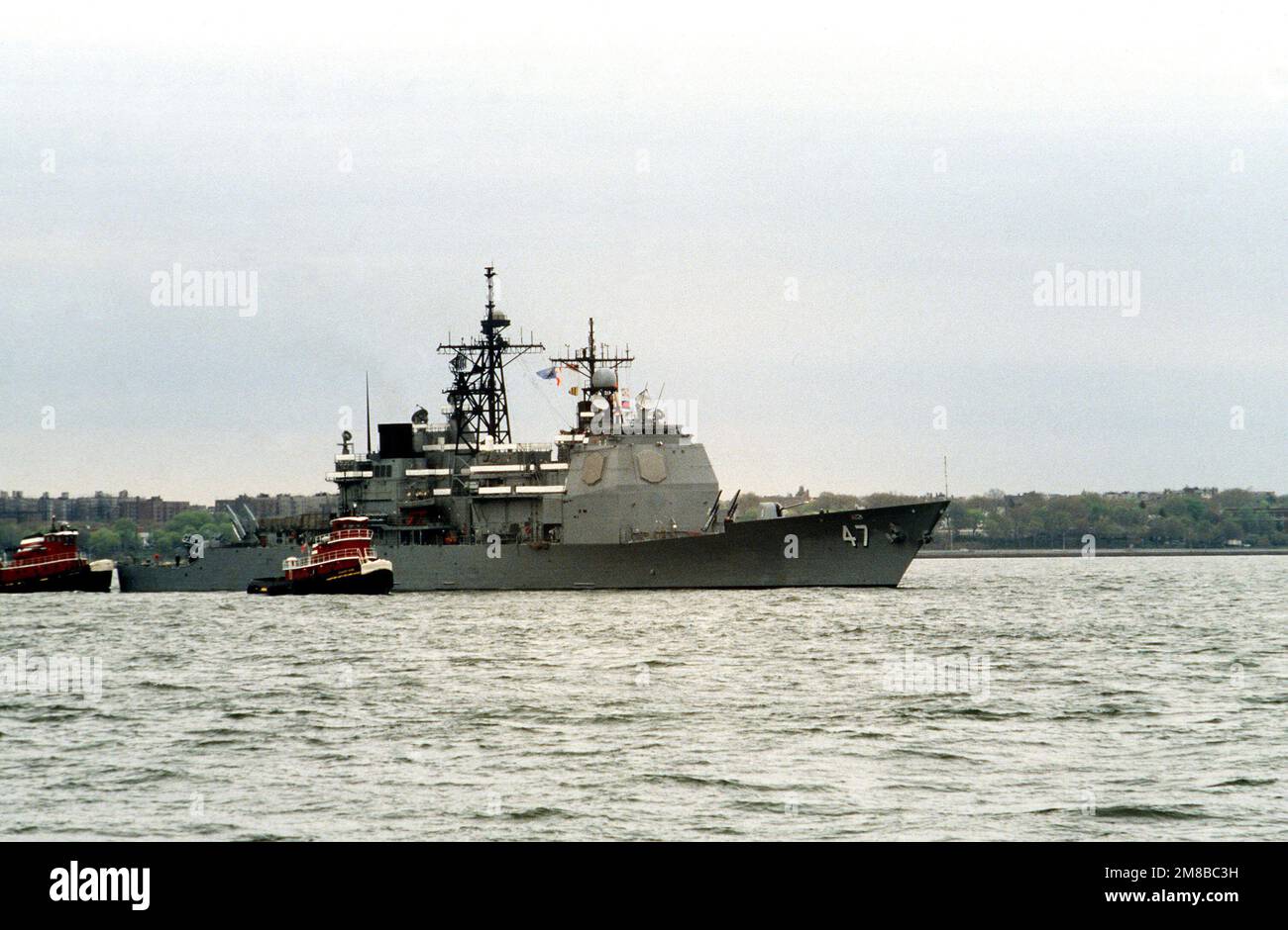 Commercial tugs approach to maneuver the guided missile cruiser USS ...