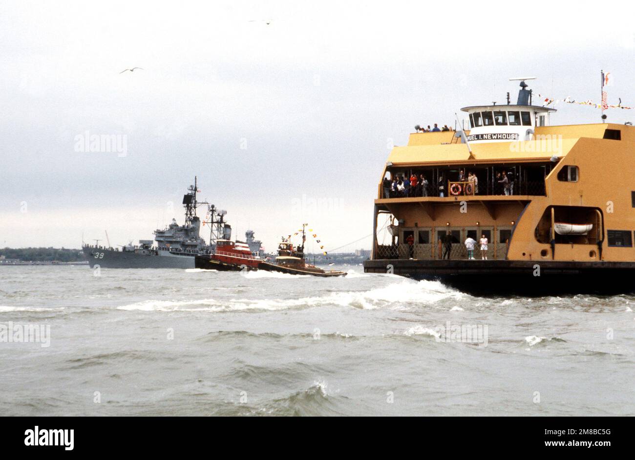 Civilians watch from a ferry as the guided missile destroyer USS ...
