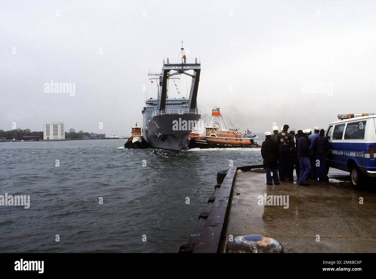 Commercial harbor tugs maneuver the tank landing ship USS FAIRFAX ...