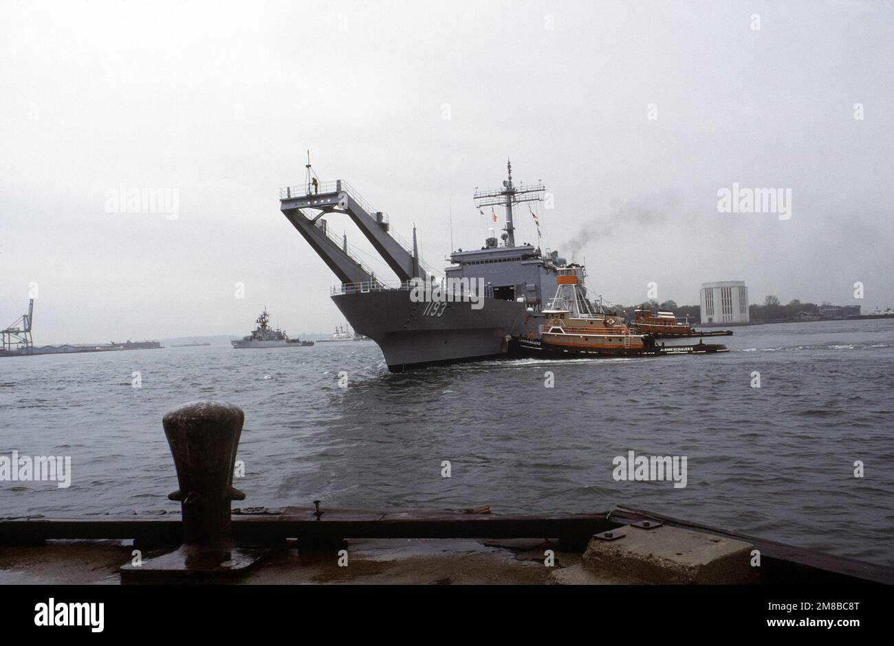 Commercial harbor tugs maneuver the tank landing ship USS FAIRFAX ...