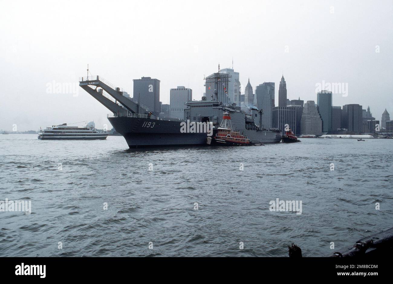 Tugs help the tank landing ship USS FAIRFAX COUNTY (LST 1193) into a ...