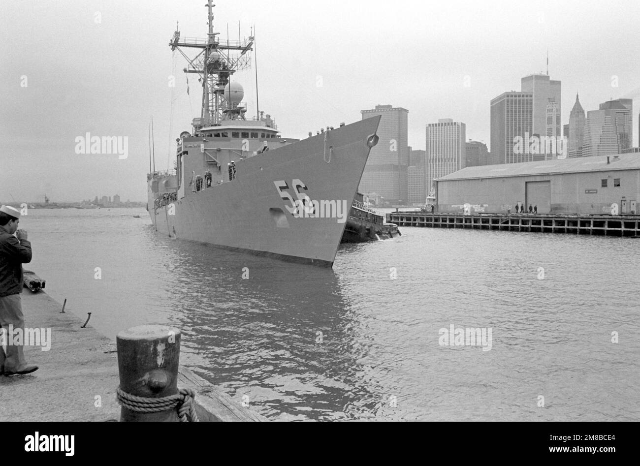 A tug boat pushes the guided missile frigate USS SIMPSON (FFG 56) into ...