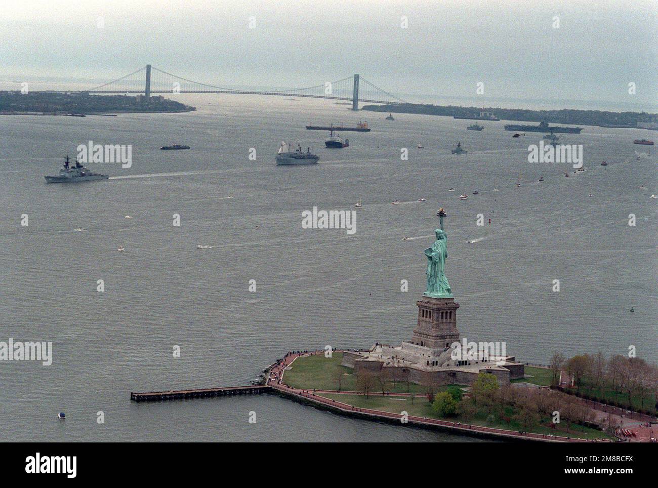 A parade of US Navy ships passes the Statue of Liberty as the vessels ...