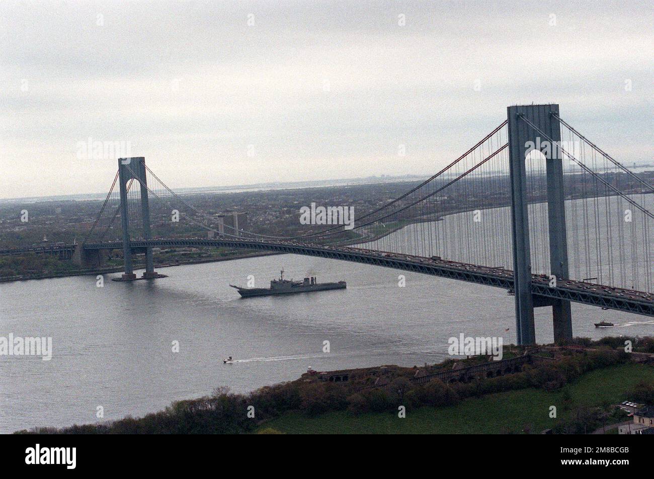 The tank landing ship USS FAIRFAX COUNTY (LST 1193) passes under the ...
