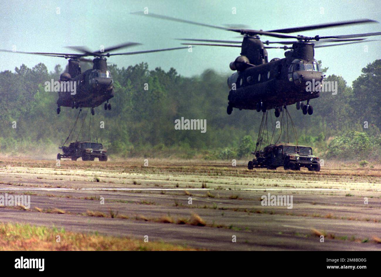 Two Army CH-47 helicopters hover as they prepare to make an external ...