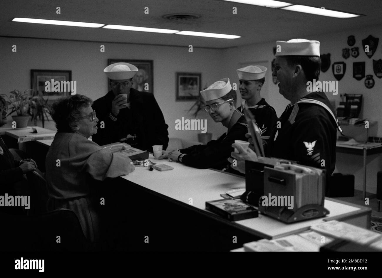 Four sailors on liberty during Fleet Week talk with the employees at a ...