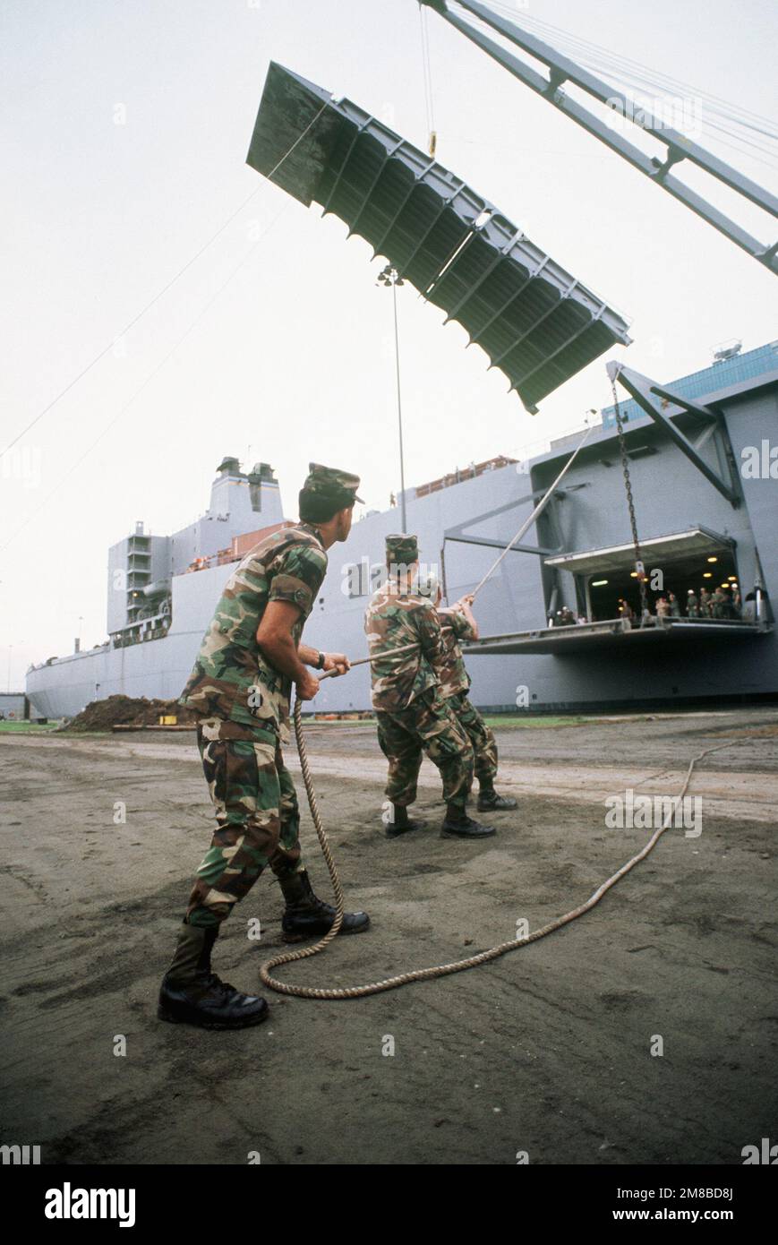 Troops help a crane lower a ramp for the unloading at the Miraflores ...