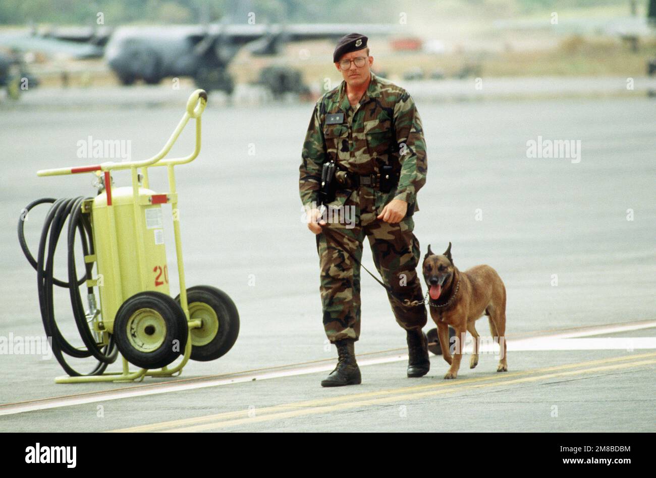 STAFF Sergeant Stanley L. Cook patrols the flight line with a dog. Base ...