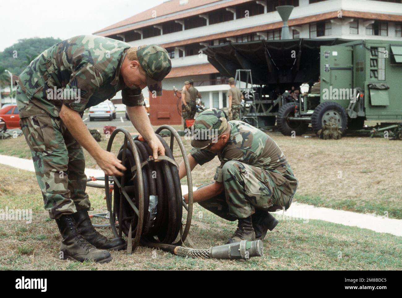 Members of the 31st Communications Squadron unwind a spool of cable for ...