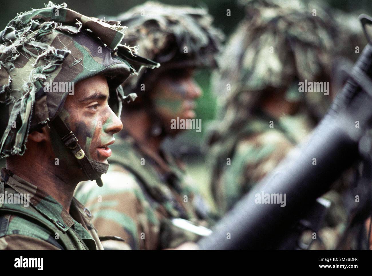 A close-up view of camouflaged soldiers during jungle training. Base ...