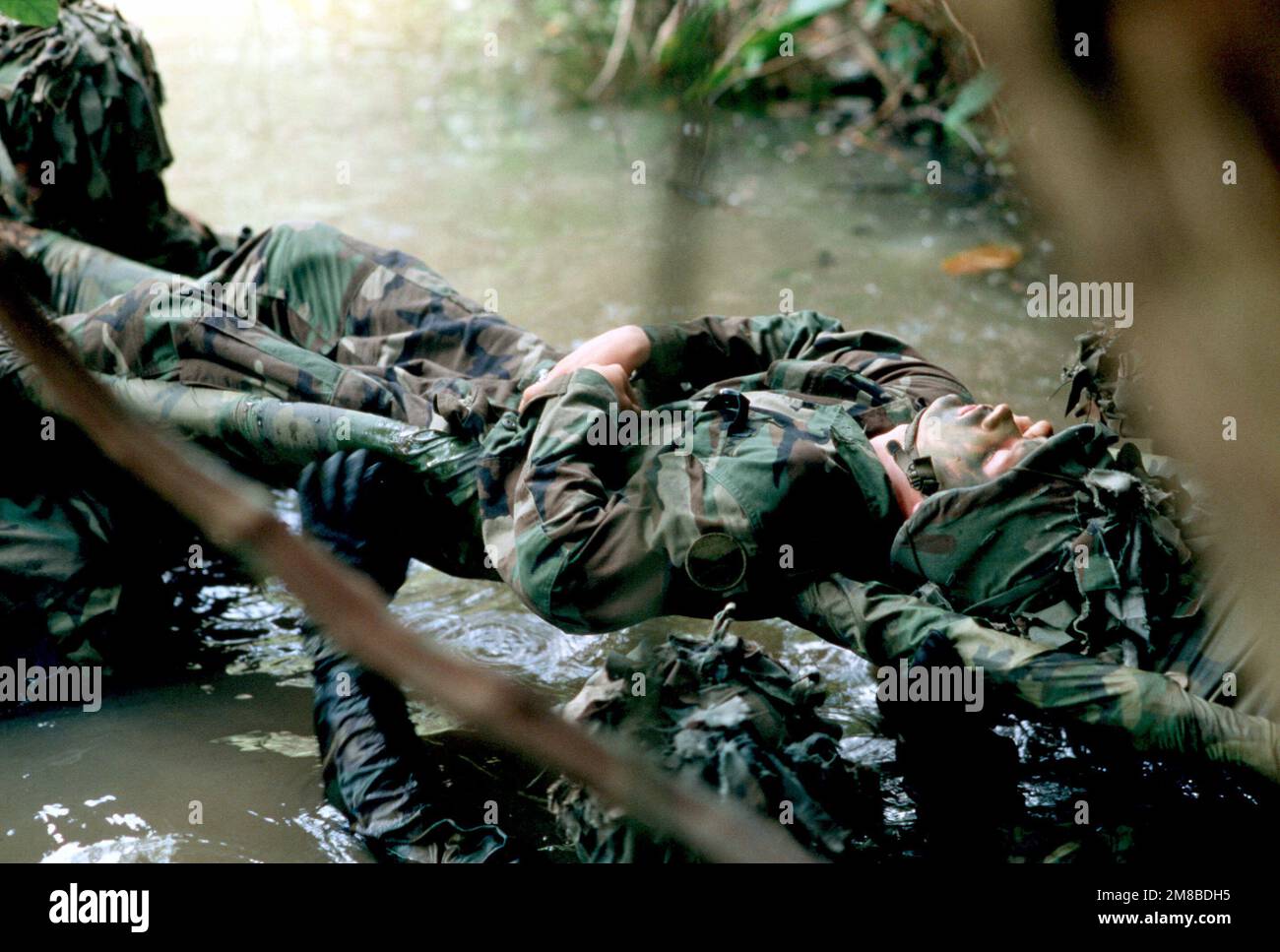 A soldier is carried across a river during a jungle operations training ...
