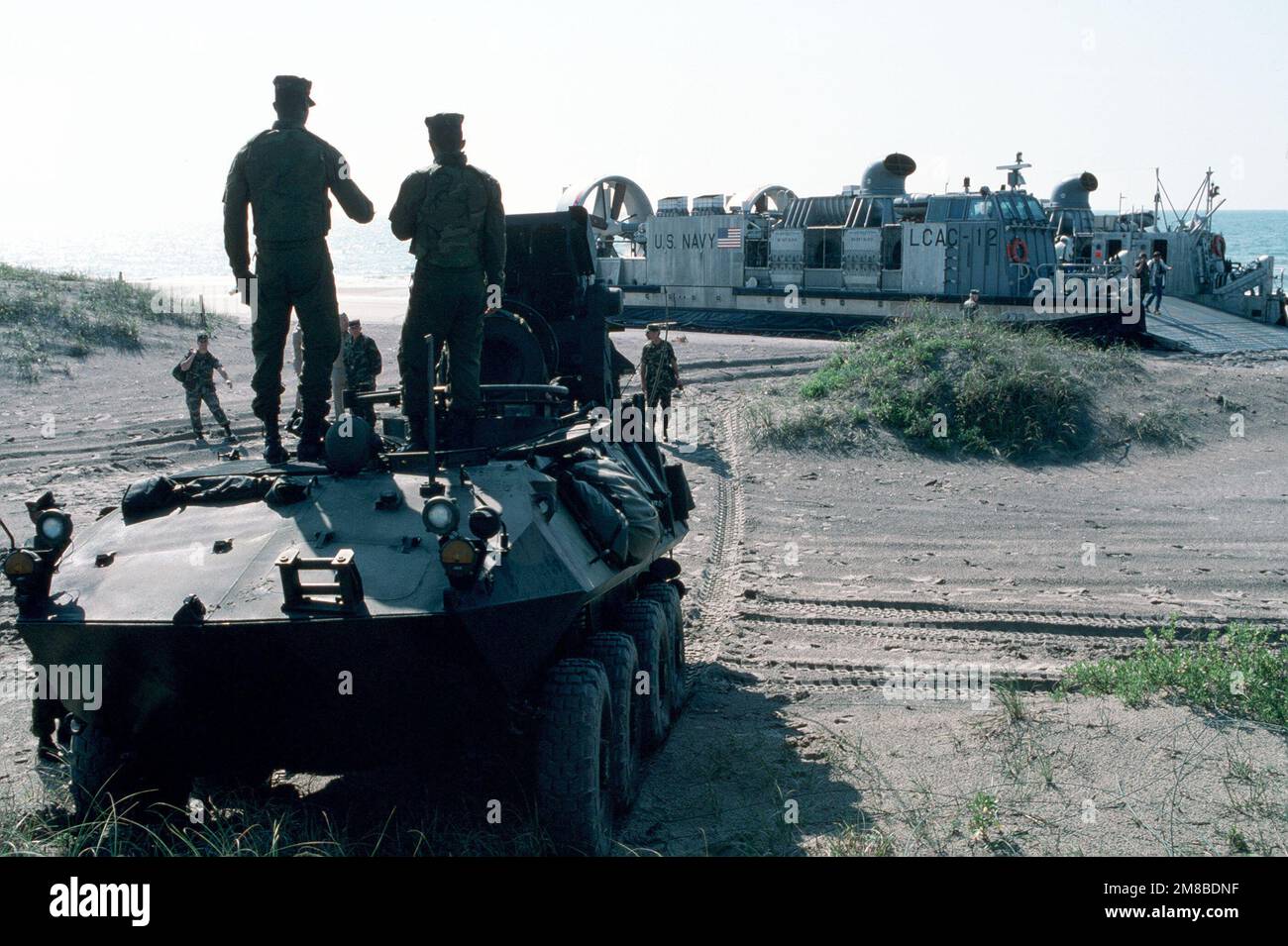 Crewmen stand atop an LAV25 light armored vehicle (LAV) on the beach ...