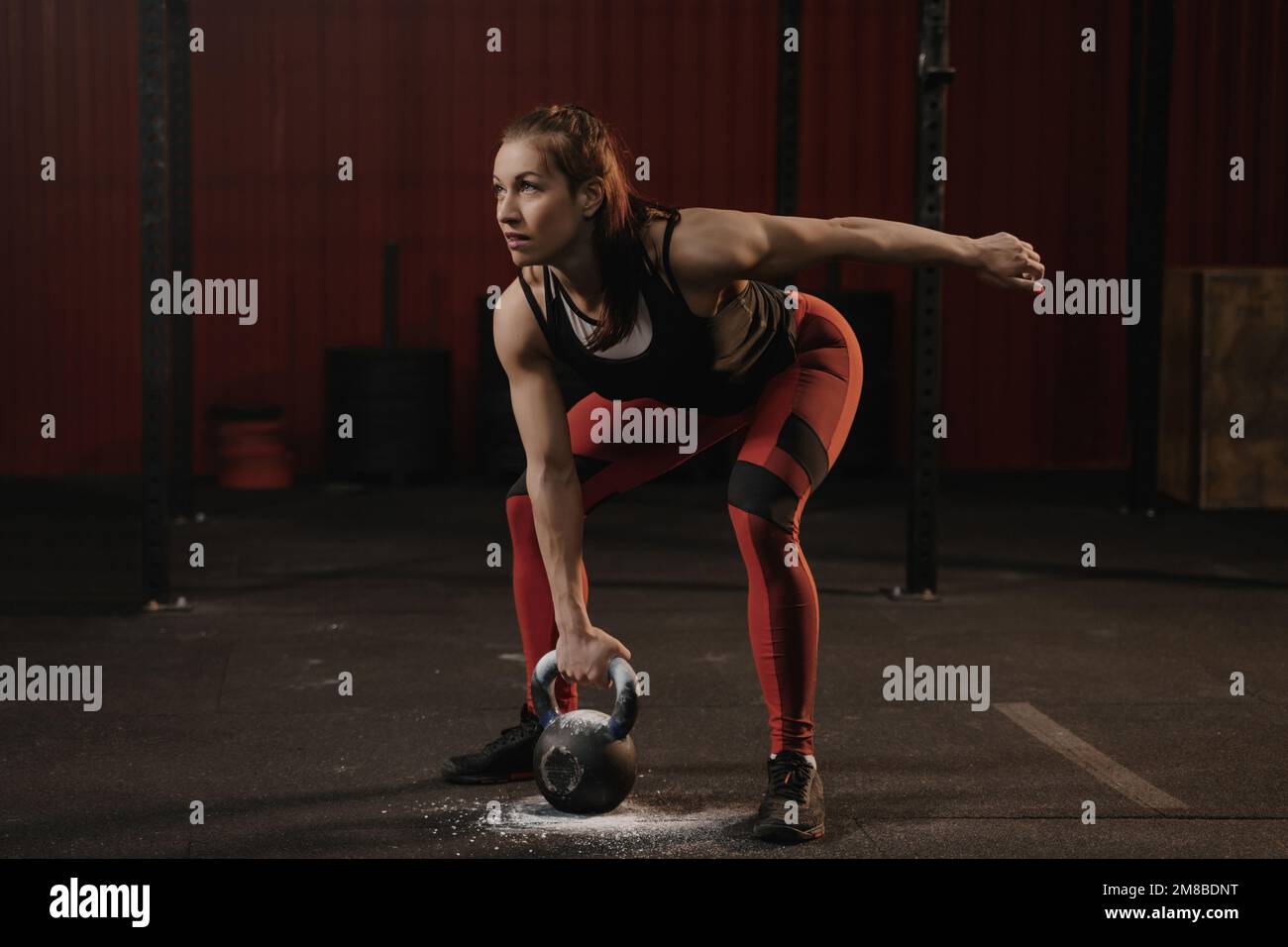 Female athlete lifting heavy weights. Sports woman holding kettlebell ...