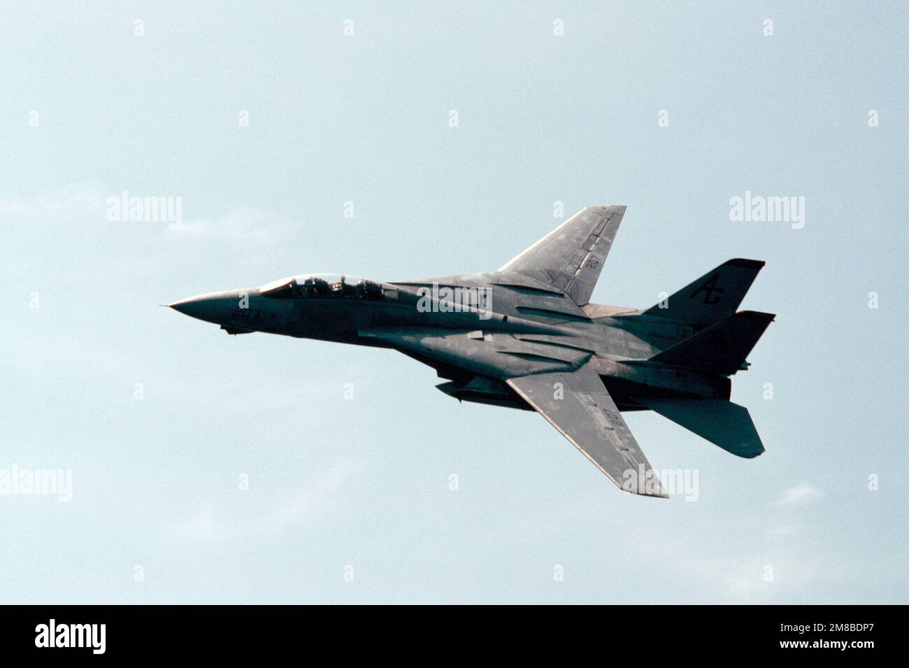 An F-14A Tomcat aircraft from Fighter Squadron 142 (VF-142) banks into ...
