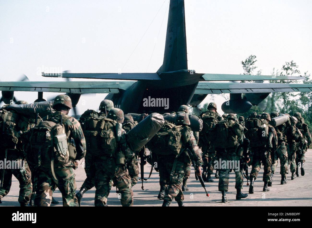 Soldiers from the 101st Airborne Division file aboard a C-130 Hercules ...