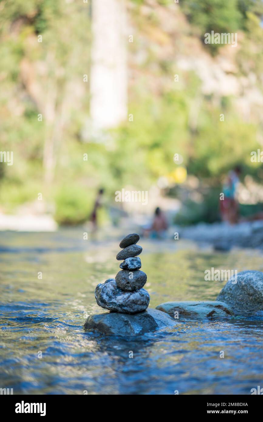 A vertical view of balanced stacked pebbles in a river Stock Photo - Alamy
