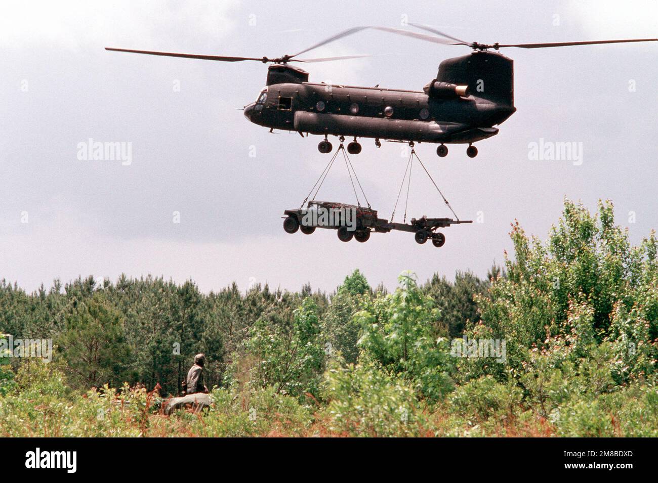 A CH-47 Chinook helicopter brings an M998 high-mobility multipurpose ...