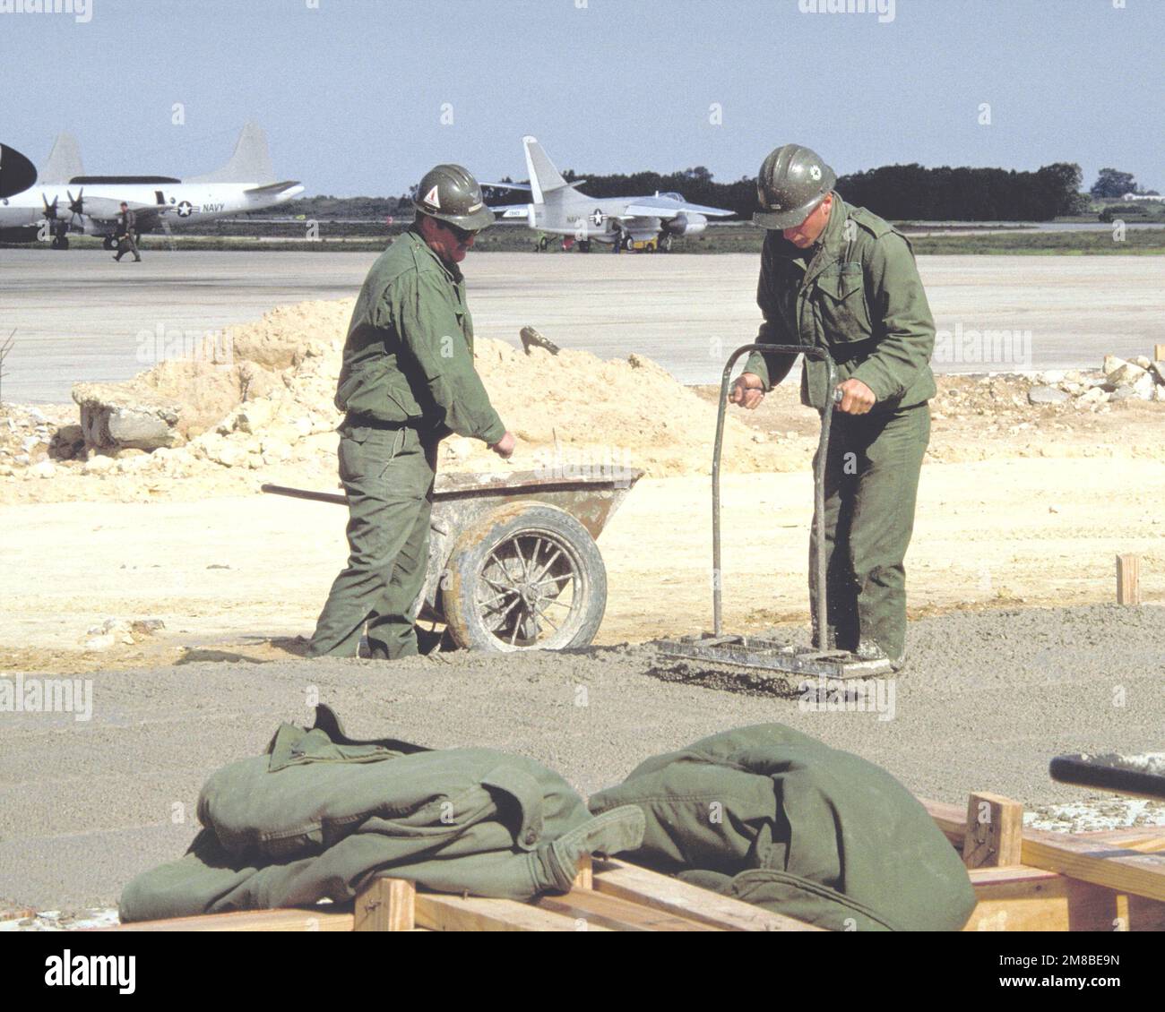 Seabees smooth down cement for new sections of the flight line. Base ...