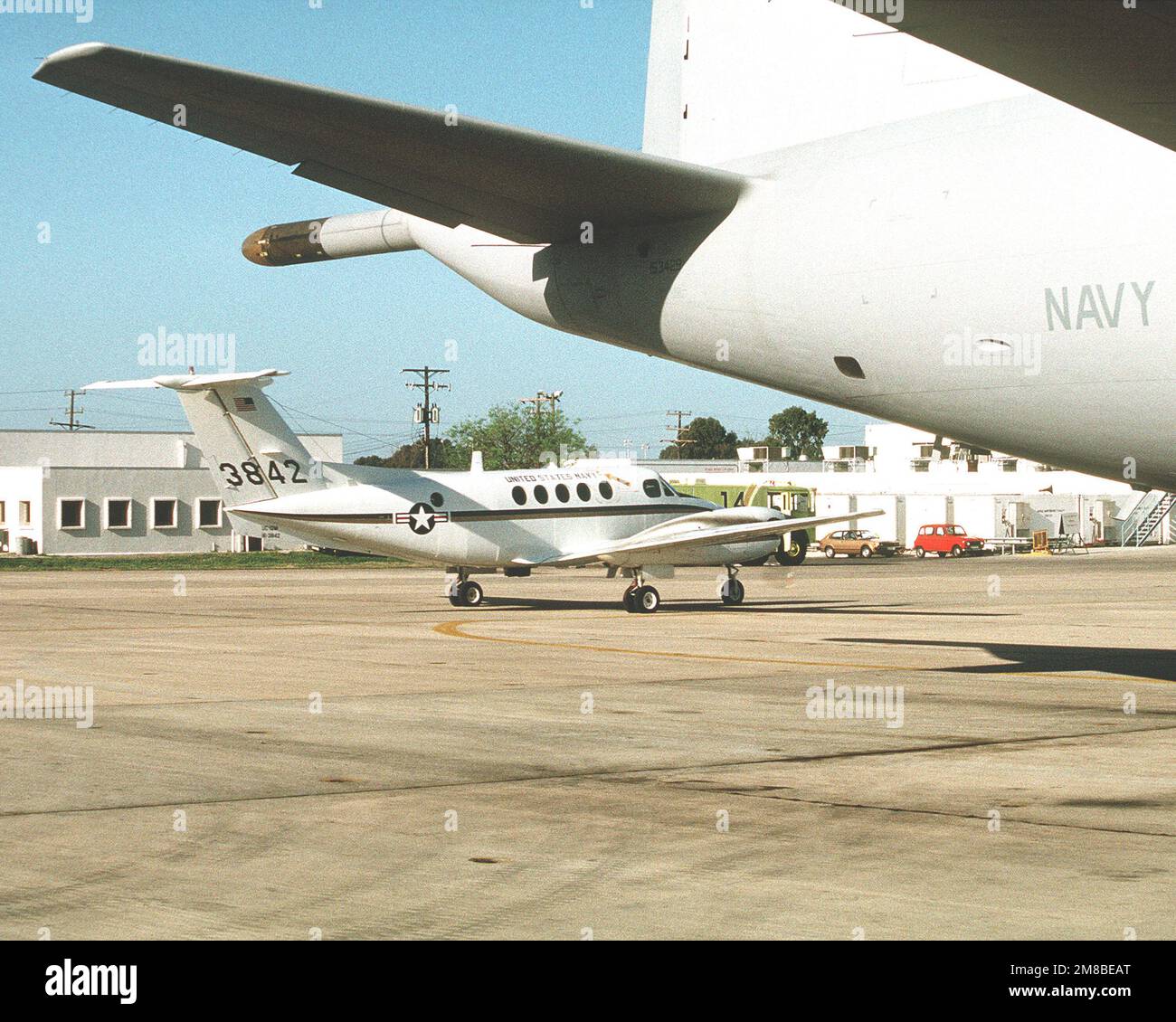 A UC-12 Huron aircraft sits on the flight line, in the shadow of the ...