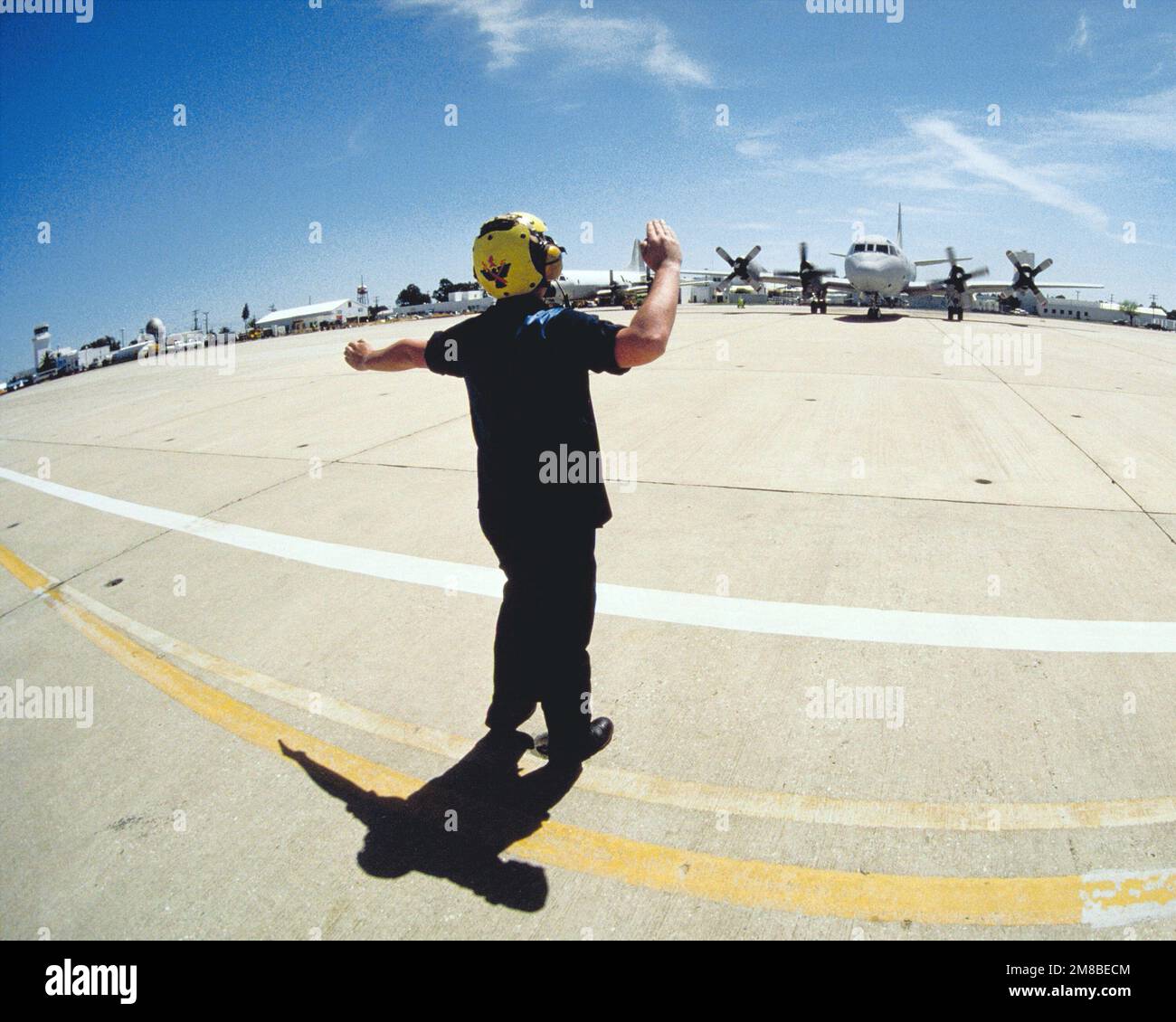 A plane director signals to a P-38 Orion aircraft of Naval Air Reserve ...