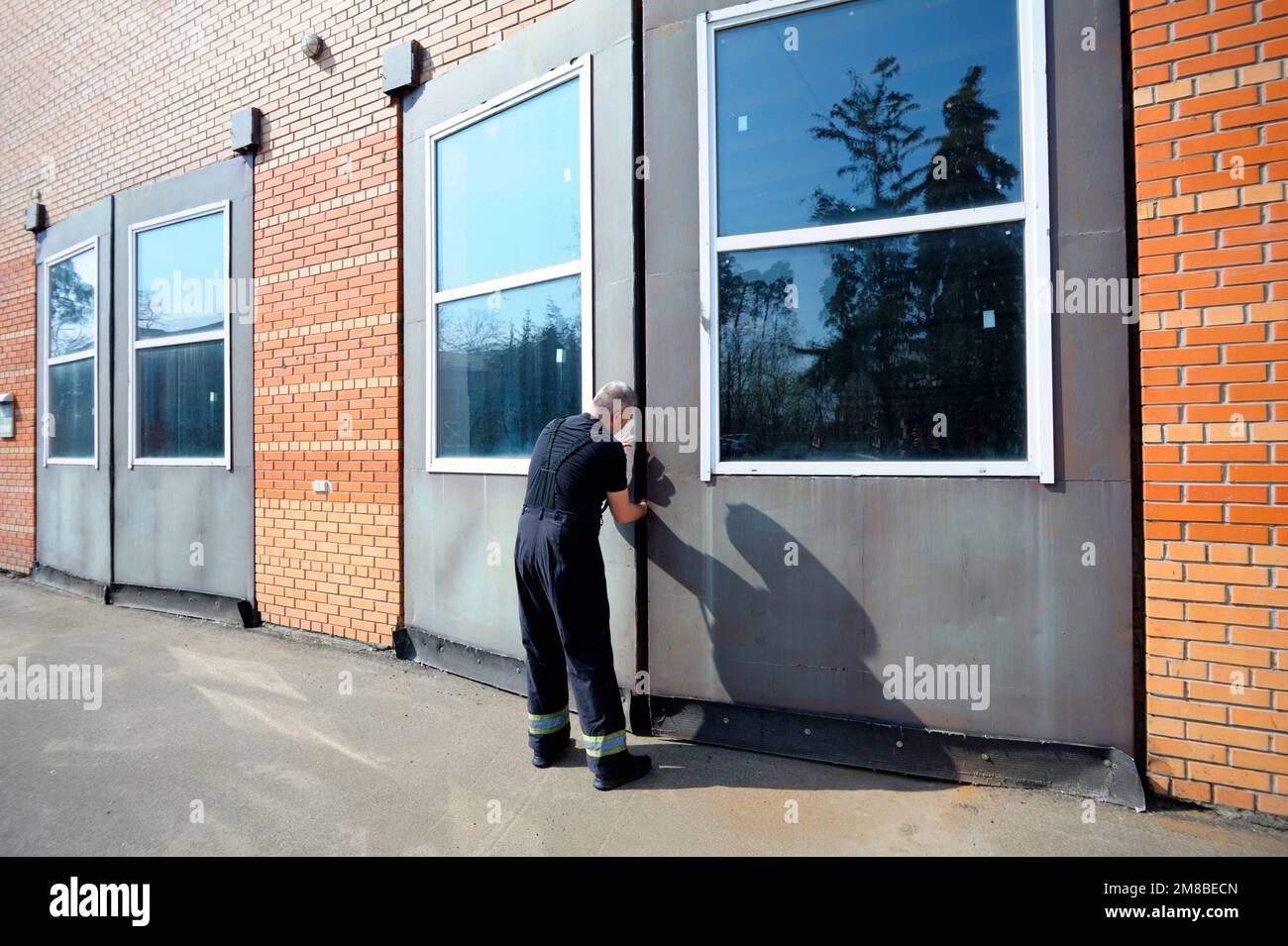 Fire territory station. Fireman opening the doors of a hangar with ...
