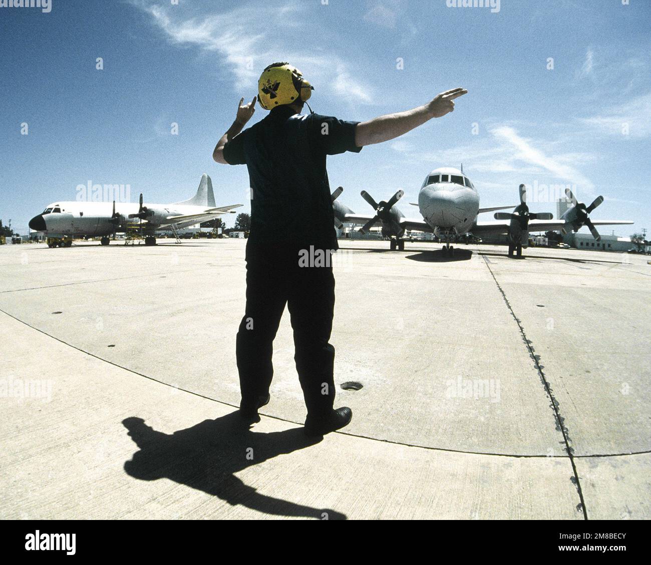 A plane director signals to a P-38 Orion aircraft of Naval Air Reserve ...
