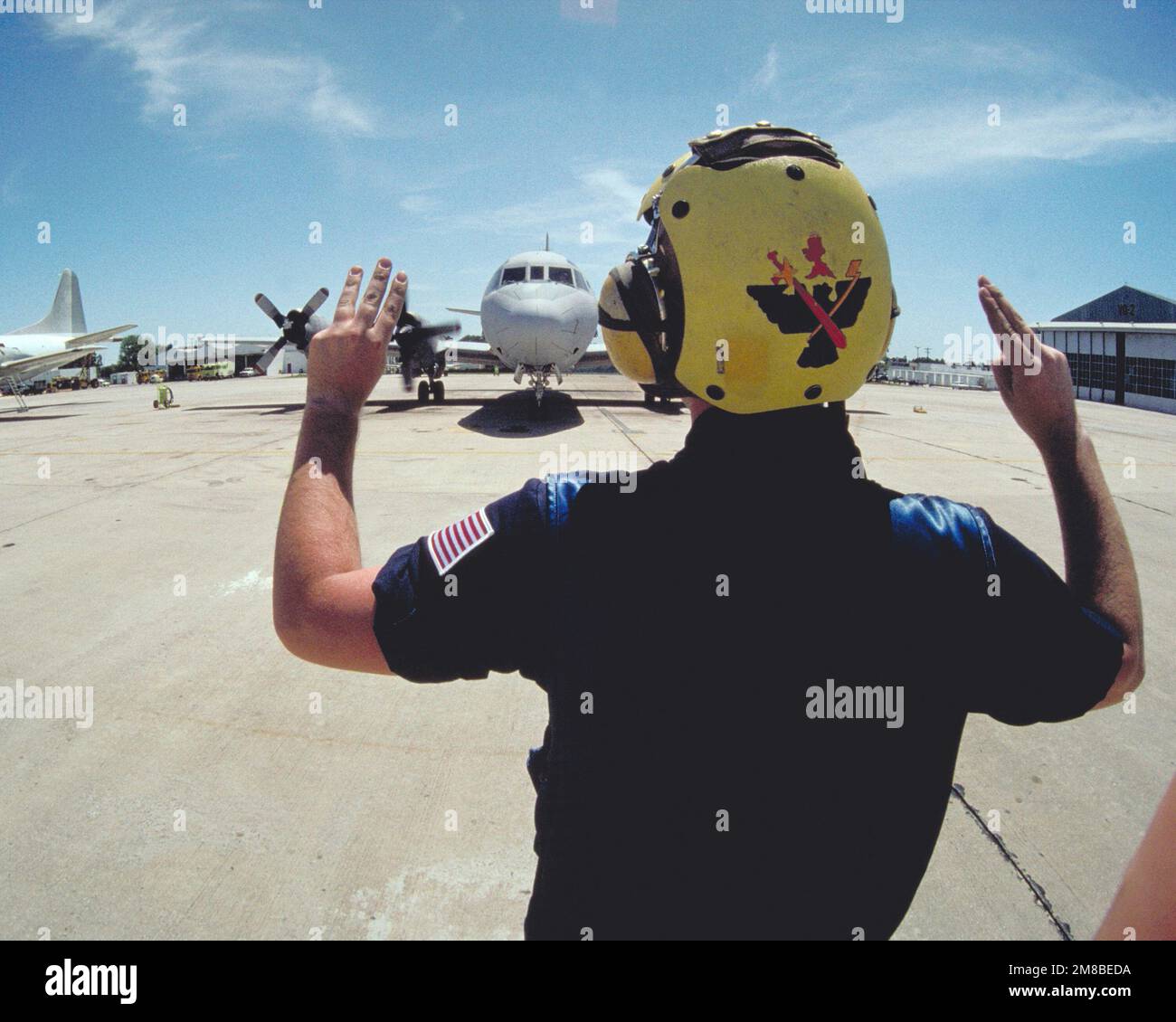 A plane director signals to a P-38 Orion aircraft of Naval Air Reserve ...