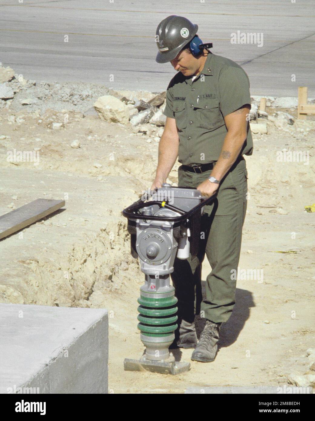 A Seabee prepares the ground for the foundation of a new building using ...