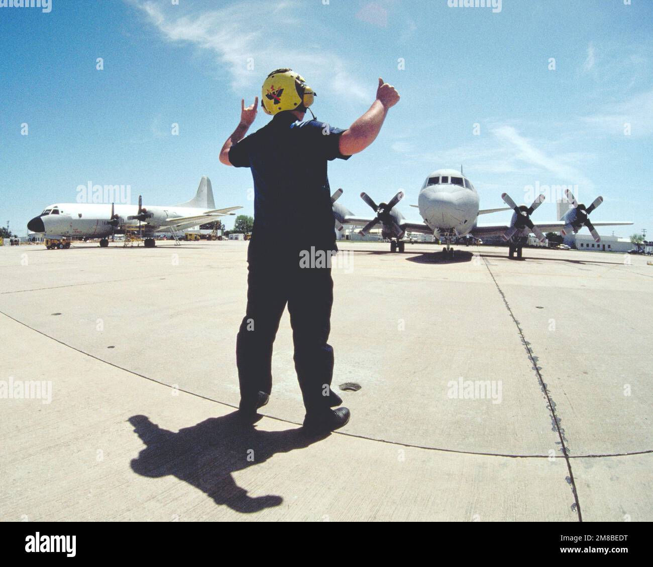 A plane director signals to a P-38 Orion aircraft of Naval Air Reserve ...