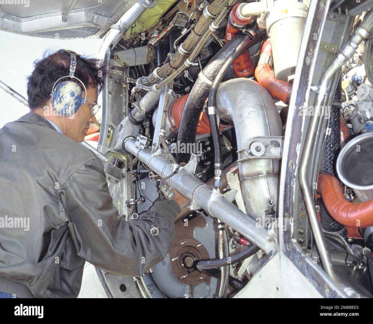 Aviation Machinist's Mate 1ST Class Ed Varvel works on the engine of a ...
