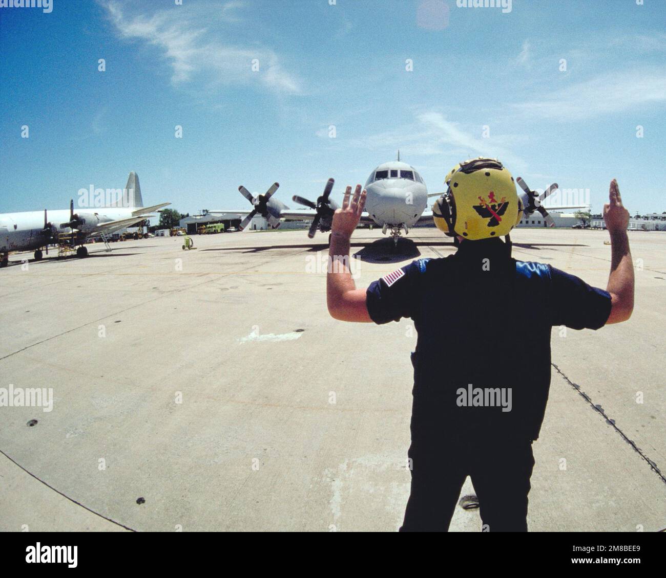 A plane director signals to a P-38 Orion aircraft of Naval Air Reserve ...