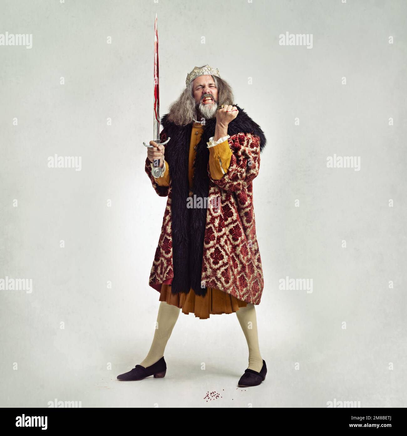 King, blood sword and man in celebration in studio isolated on a gray ...