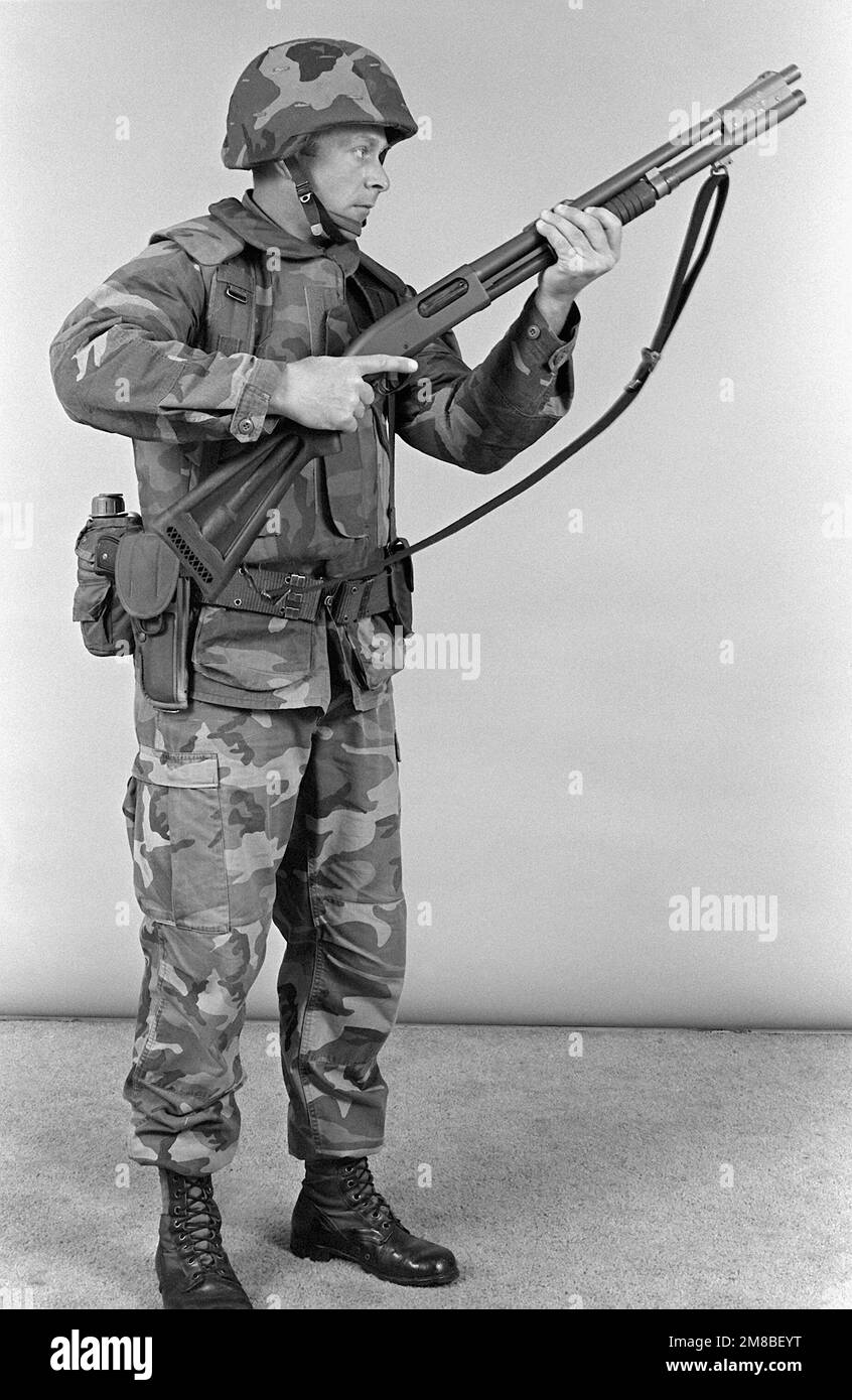 A Marine demonstrates a ready position with an M-870, Mark 1 12-gauge ...