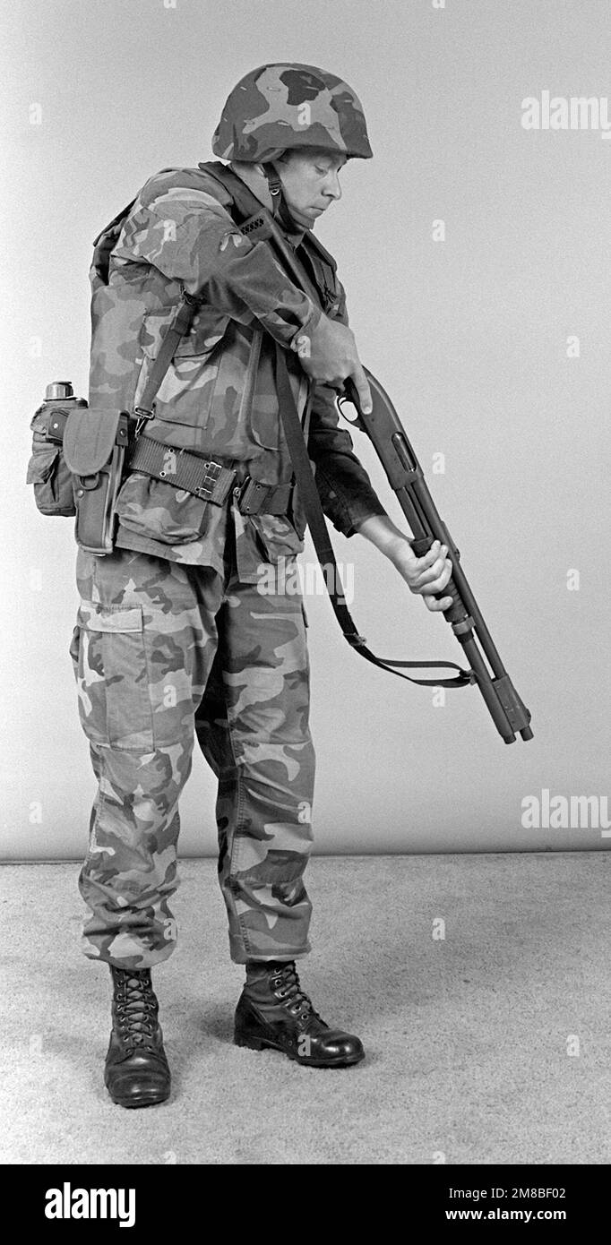 A Marine demonstrates a ready position with an M-870, Mark 1 12-gauge ...