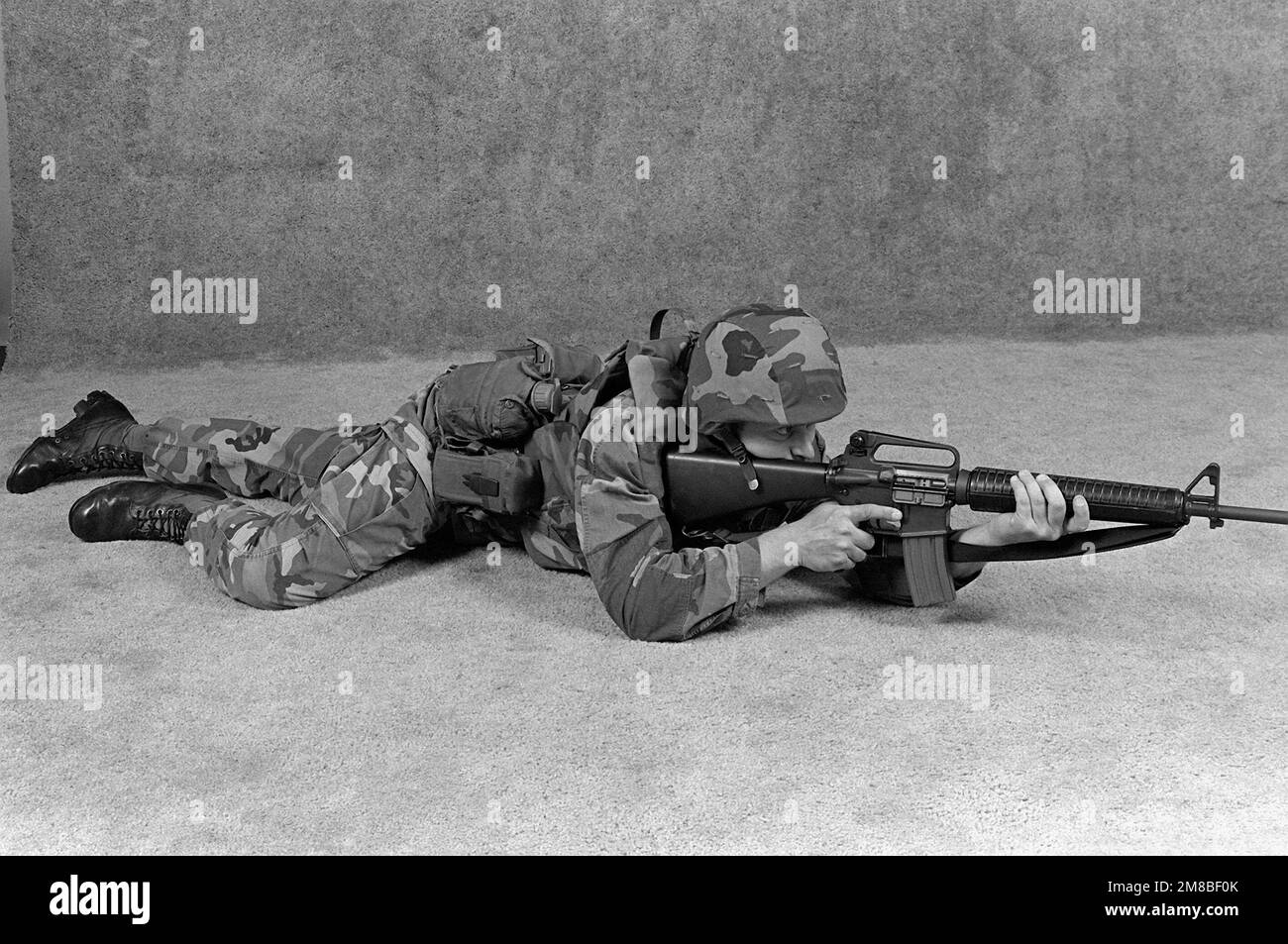 A Marine demonstrates a prone firing position with an M-16A2 5.56mm ...