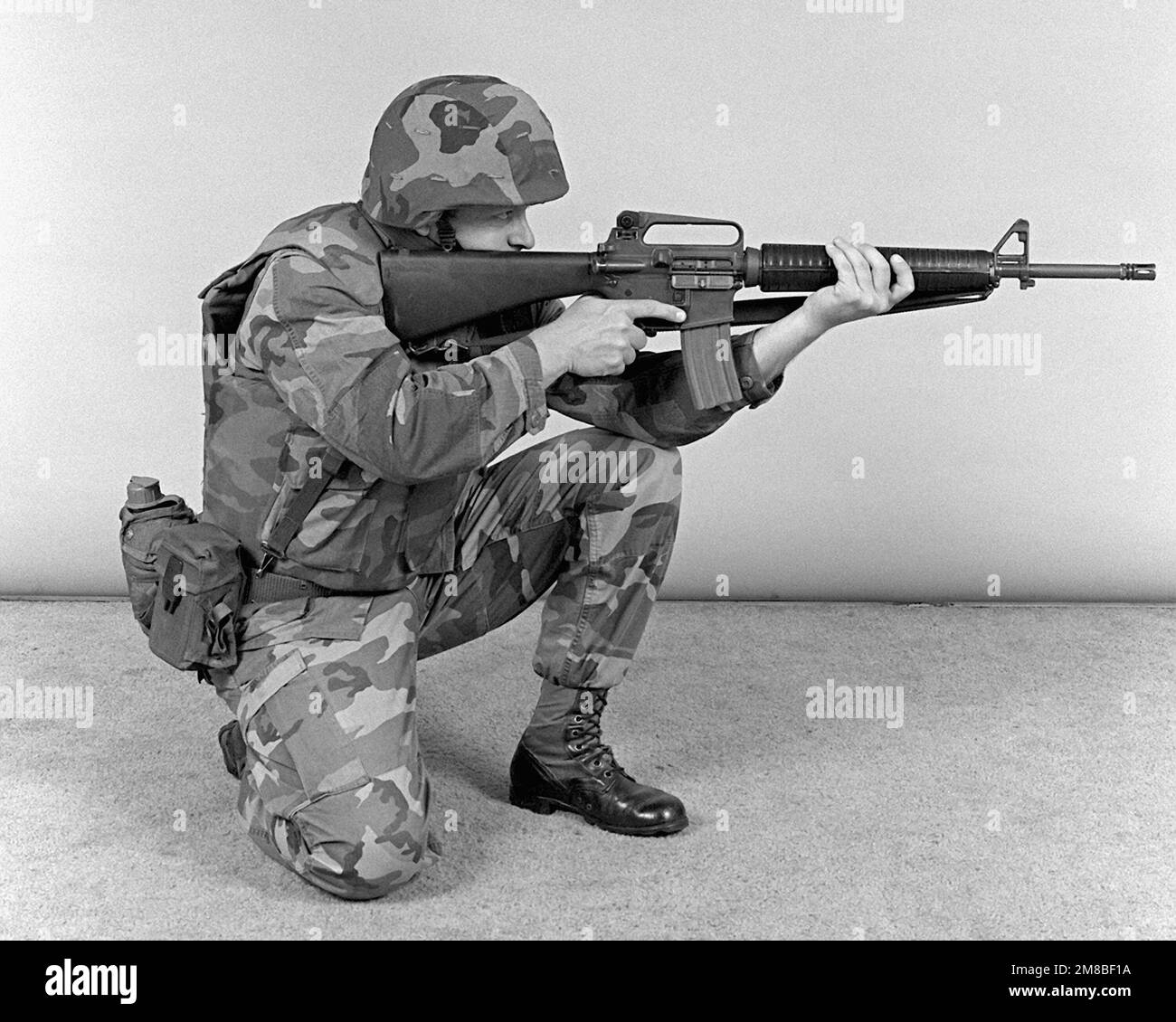 A Marine demonstrates a kneeling firing position with an M-16A2 5.56mm ...