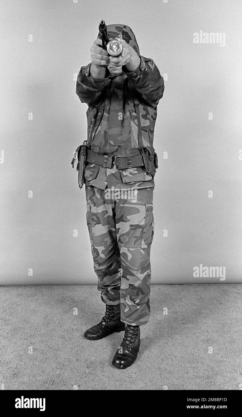 A Marine demonstrates a standing firing position with an M-9 9mm pistol ...