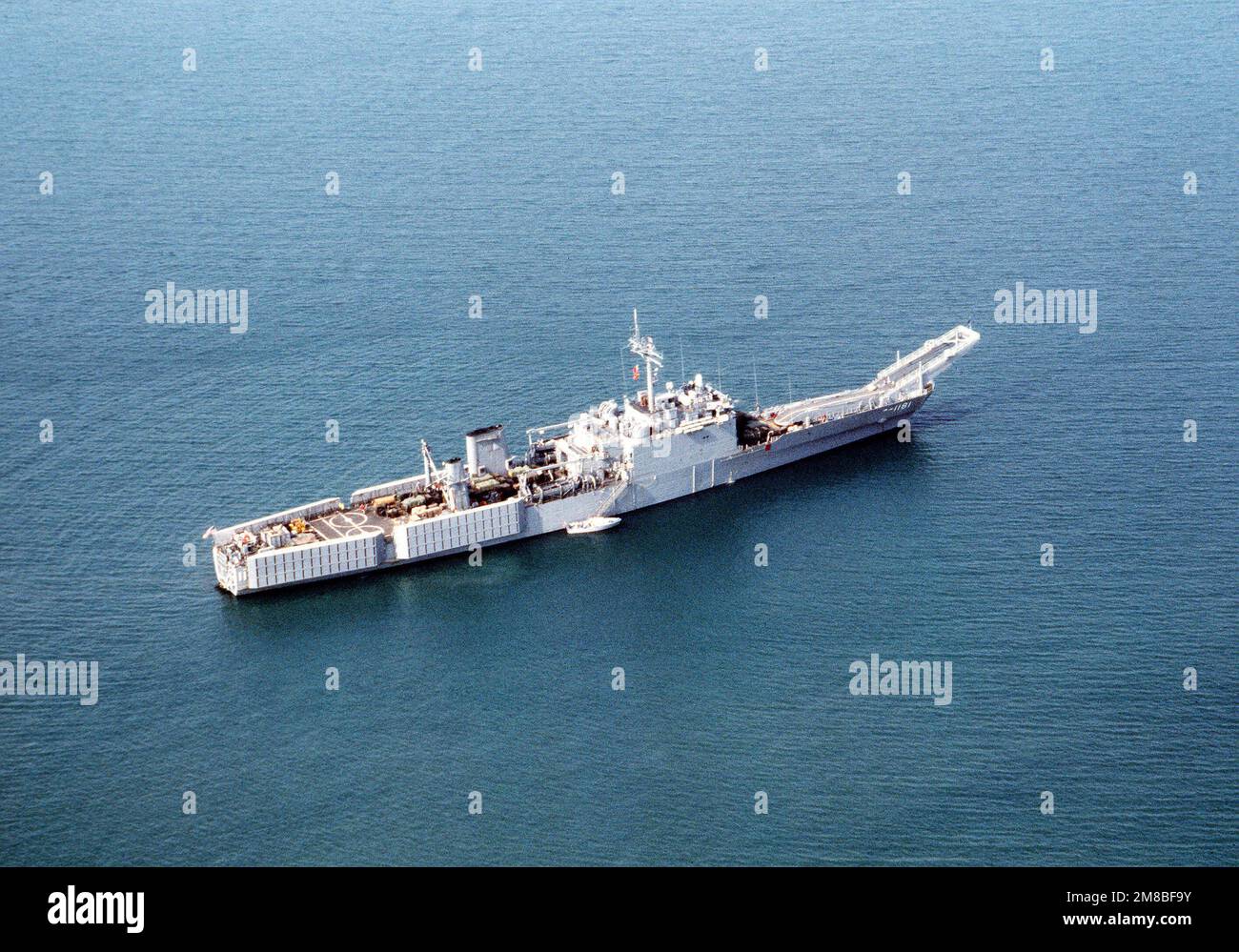 The tank landing ship USS SUMTER (LST 1181) sits offshore during the ...