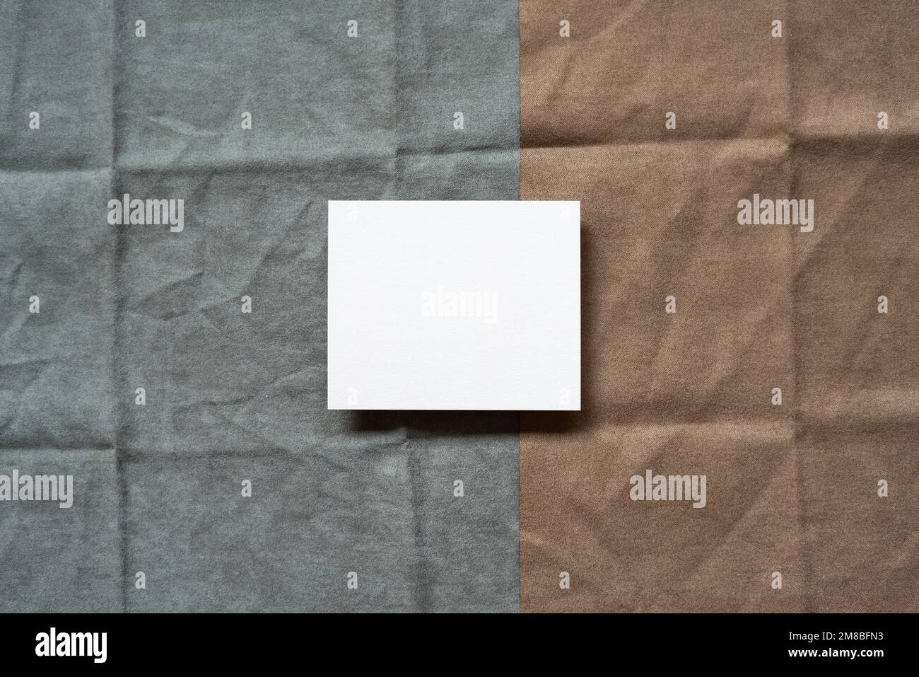 Blank memo pad on gray and brown fabric background. top view, copy ...