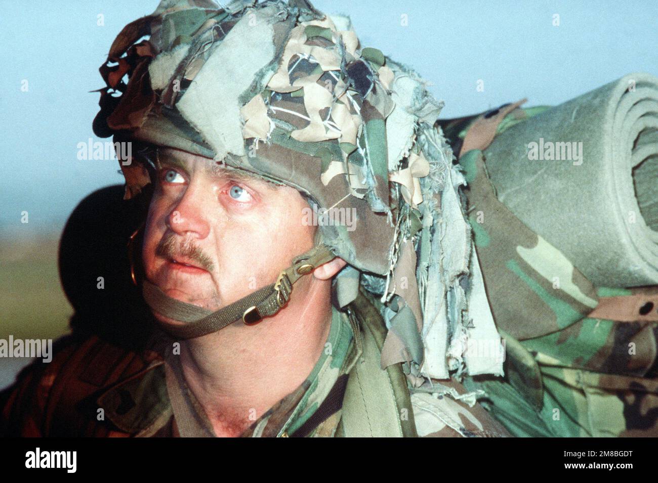 A soldier of the 7th Light Infantry Division waits with his gear on the ...