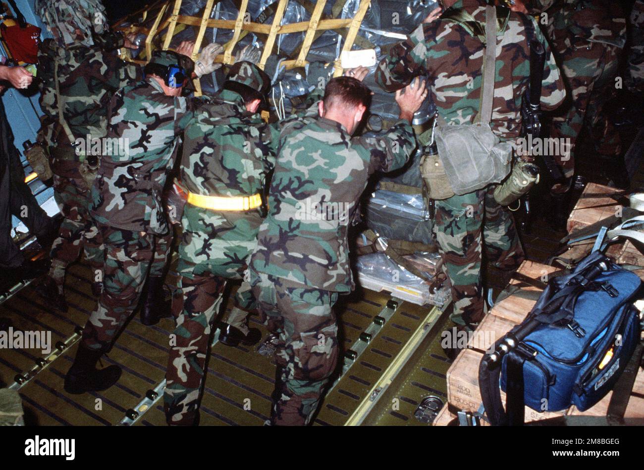 Panama-bound soldiers of the 7th Light Infantry Division push a pallet ...