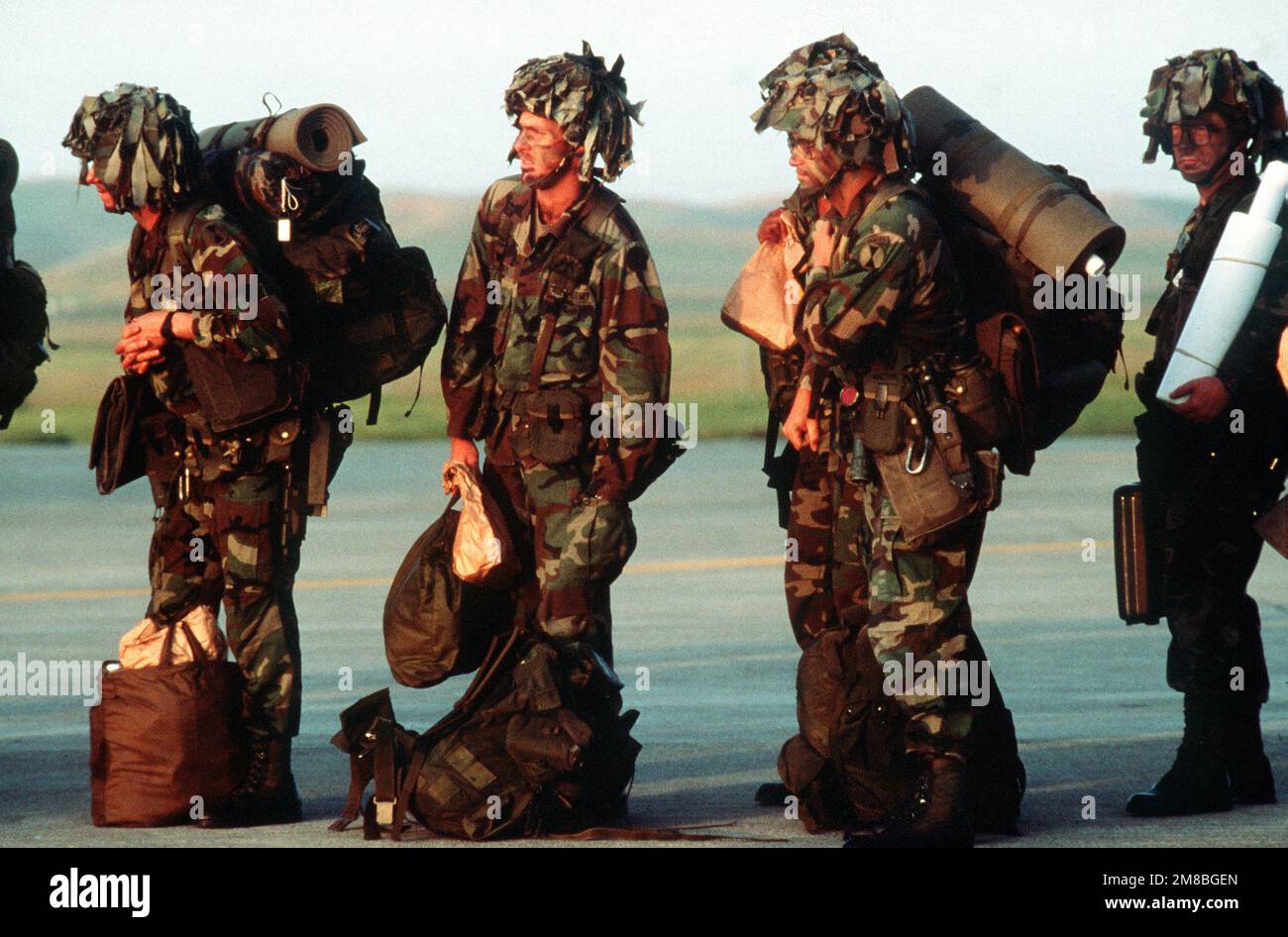 Soldiers of the 7th Light Infantry Division wait with their gear on the ...