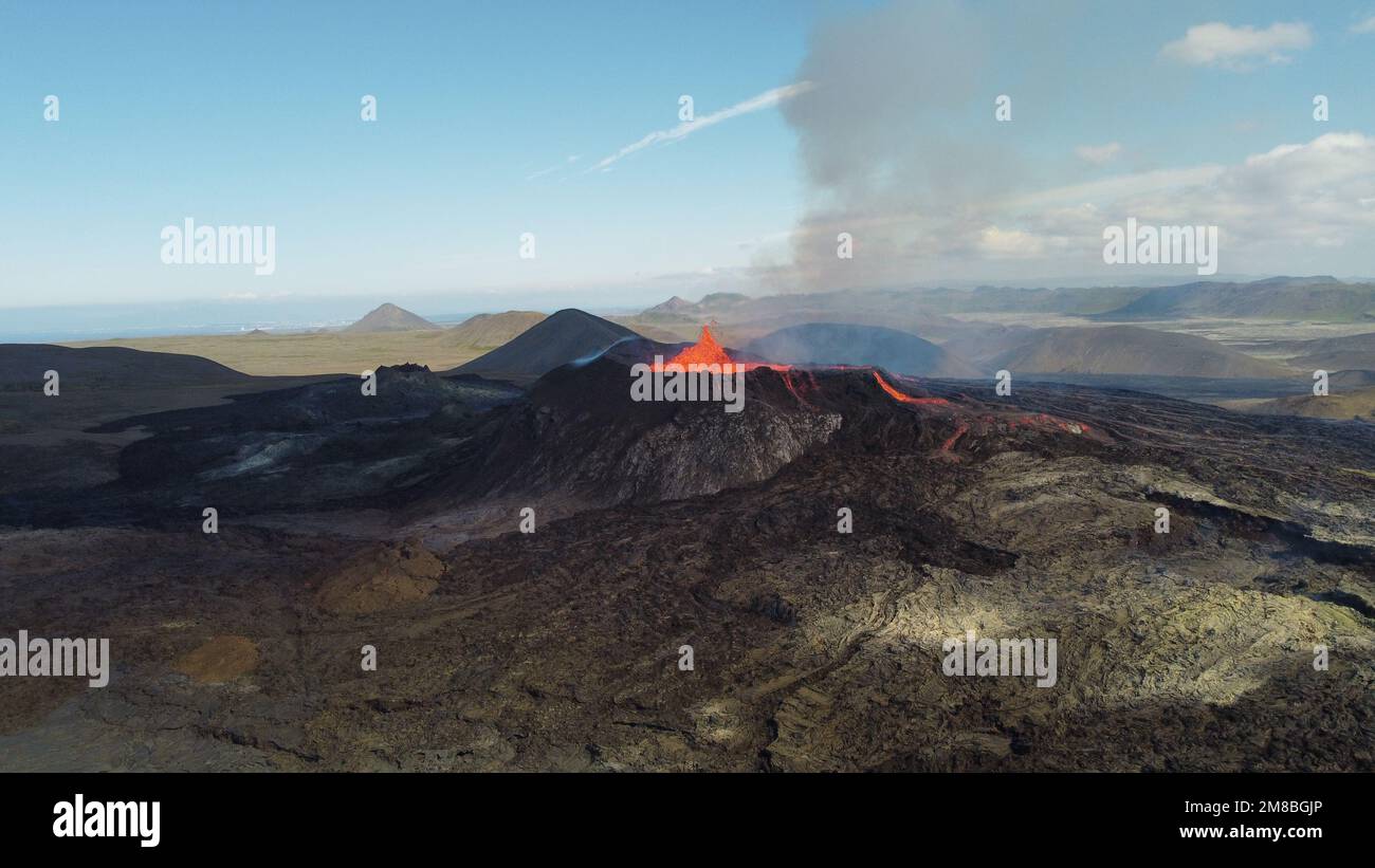 A landscape of erupting Mauna Loa Volcano in Hawaii with smoke and blue ...