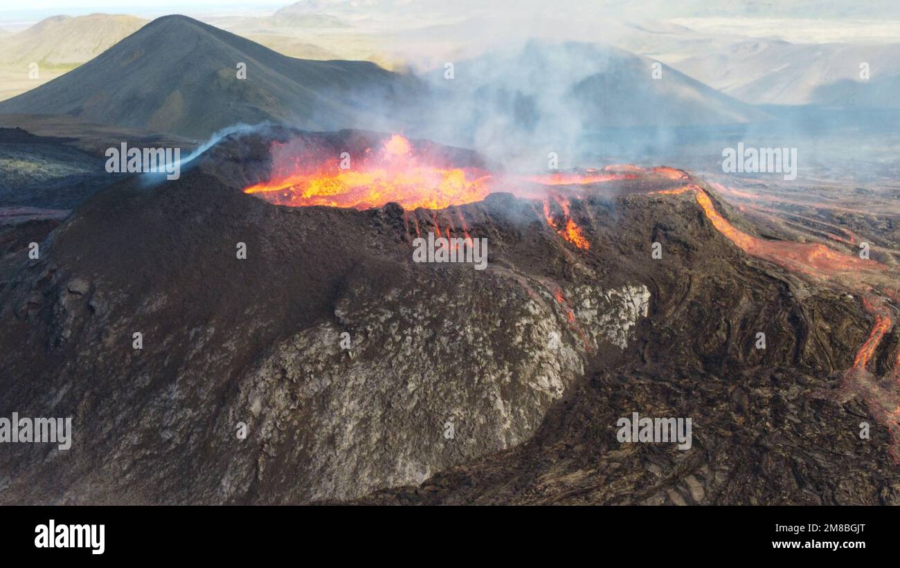 A landscape of erupting Mauna Loa Volcano in Hawaii with smoke and blue ...