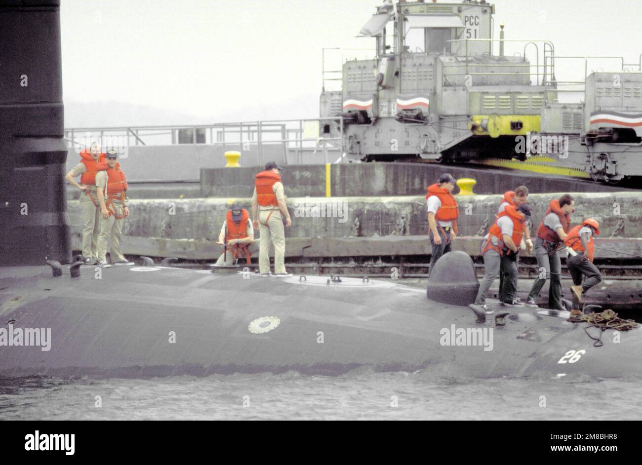 Lifejacketed crewmen secure tow lines on the nuclear powered attack ...