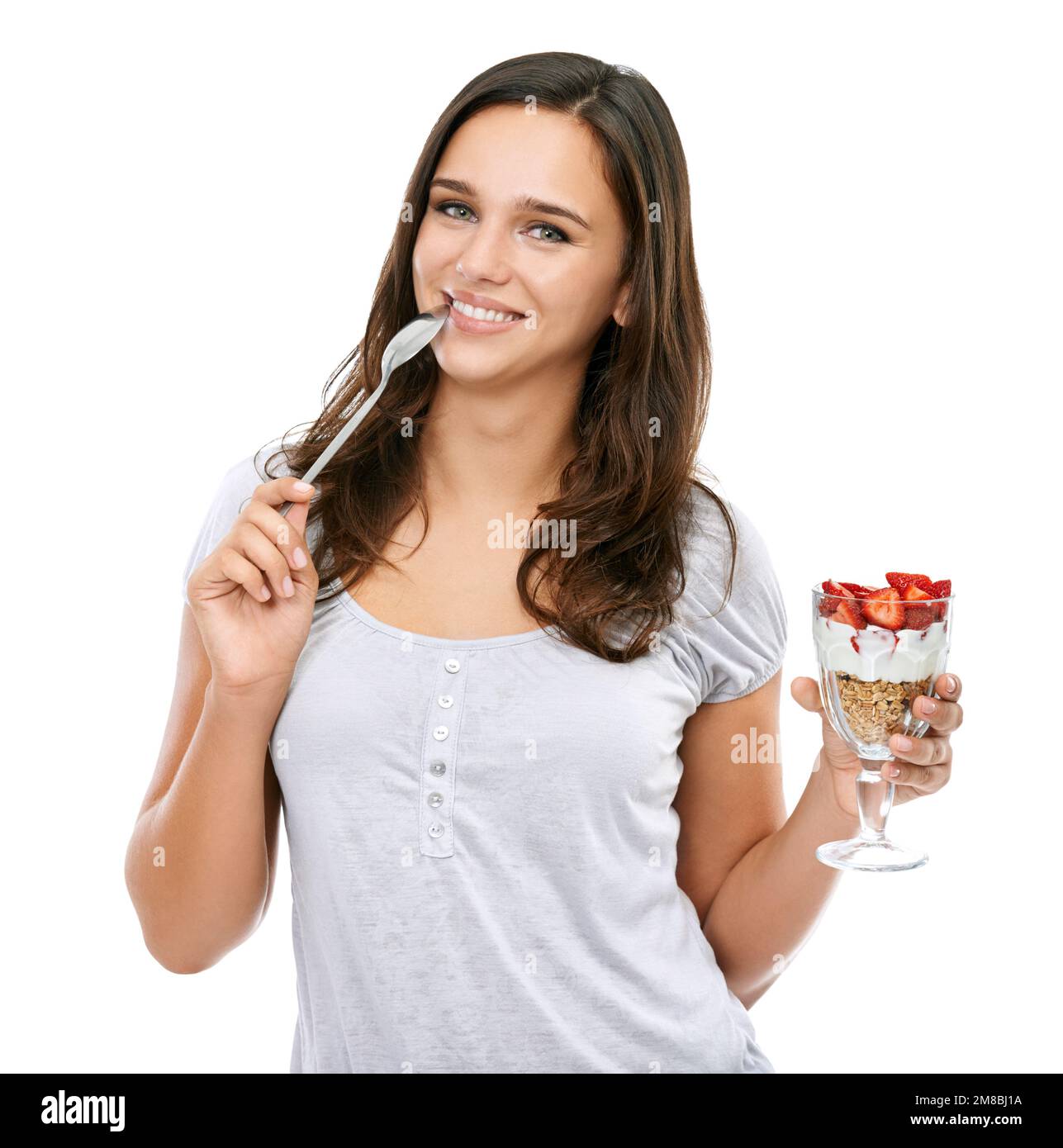 Woman, portrait and eating dessert food in studio with strawberry fruit ...