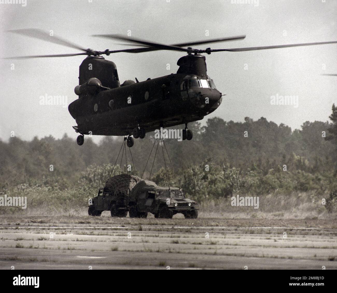 An Army CH-47 Chinook helicopter drops off a pair of M998 High-Mobility ...