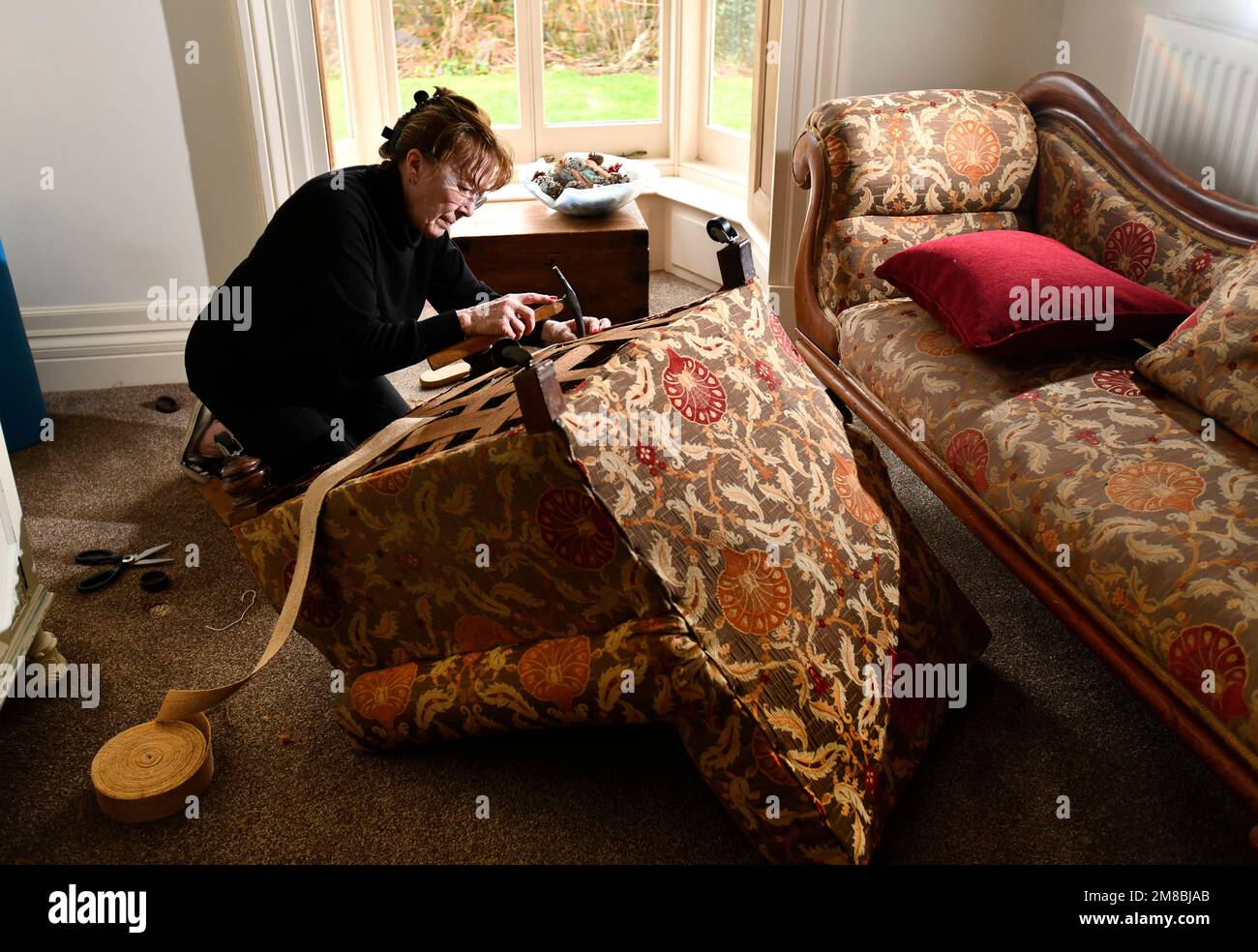 Woman repairing upholstering old antique chair in Britain, Uk. DIY ...