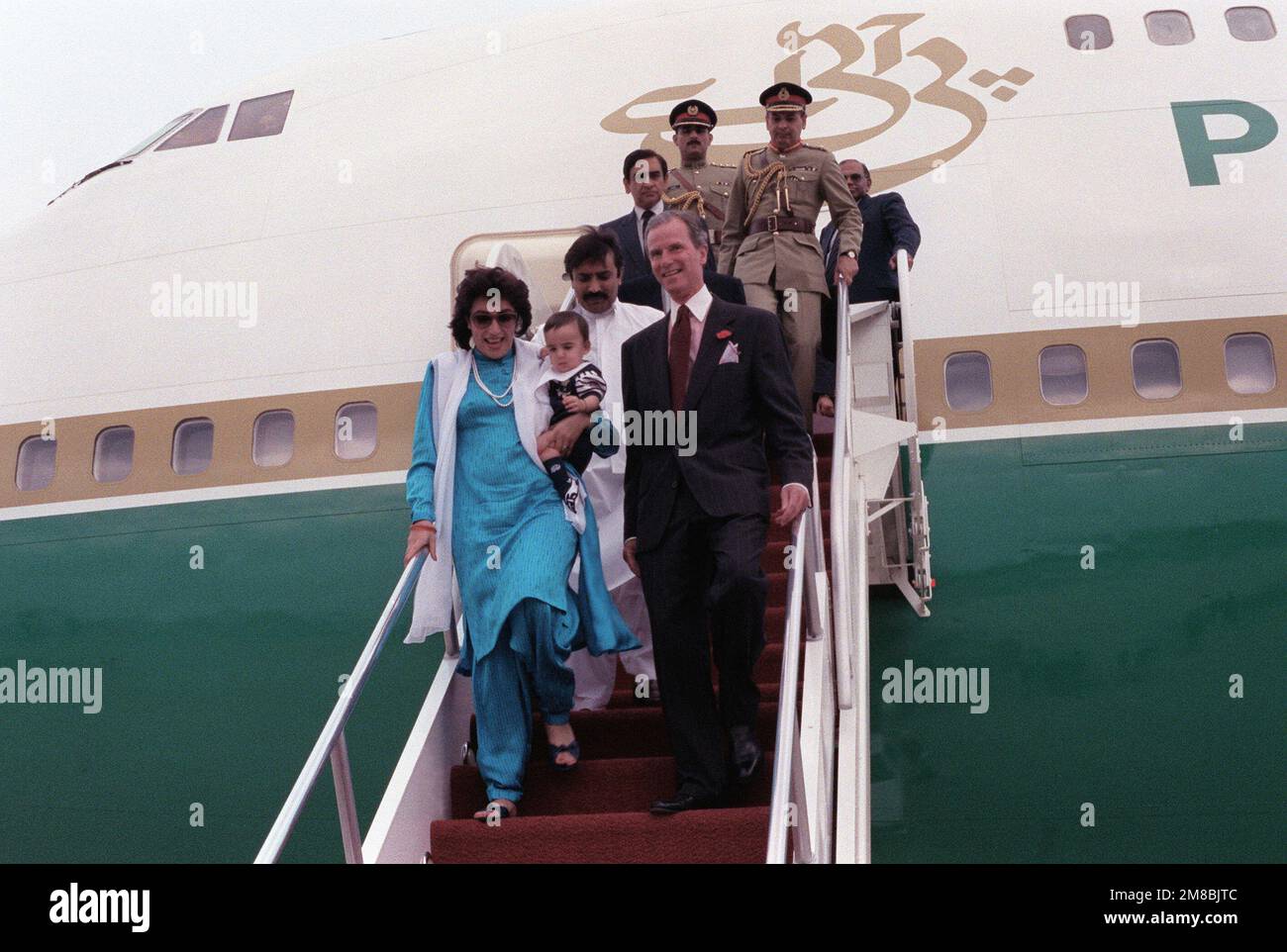 Benazir Bhutto, the Prime Minister of Pakistan, carries a child as she ...