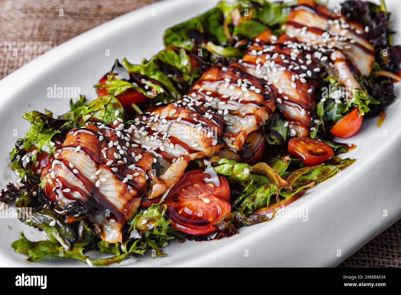Fried eel fish with sauce and sesame, on a plate Stock Photo - Alamy